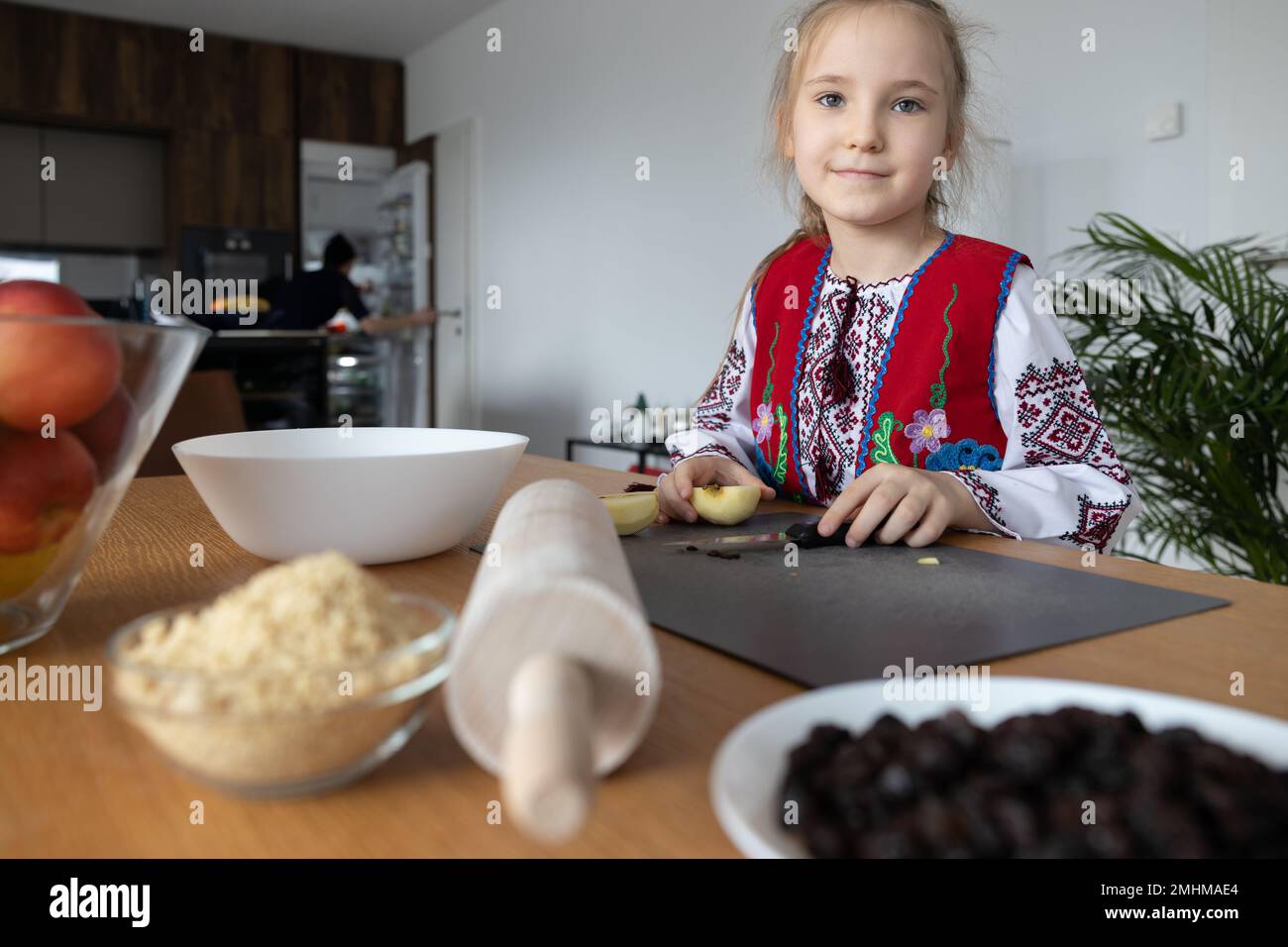 Ukrainian girl helps in the kitchen with pastries, looks directly into ...