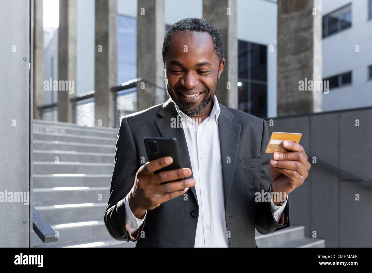 Happy and successful african american man in business suit outside ...