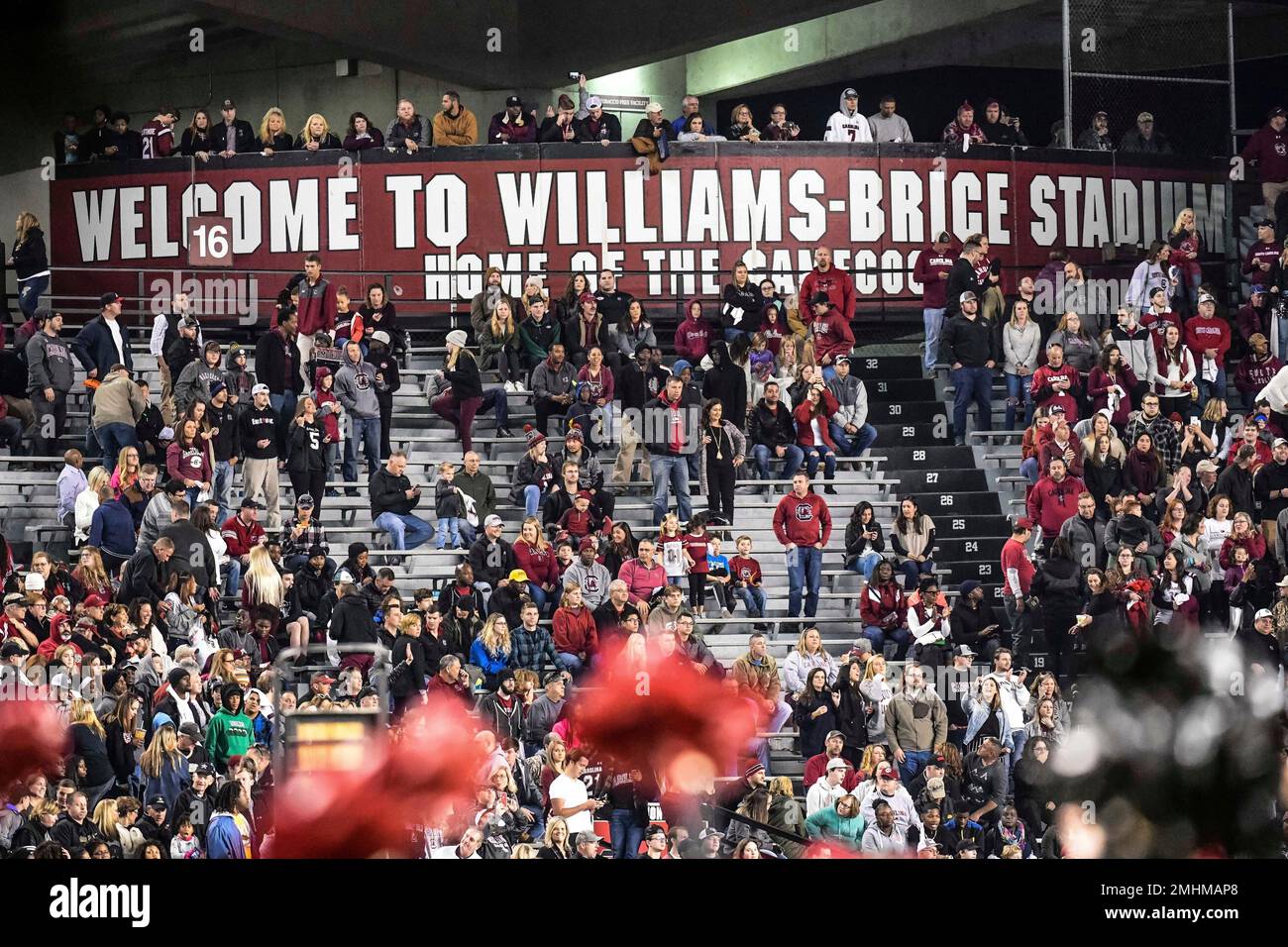 College football fans watch the marching band and cheerleaders before ...