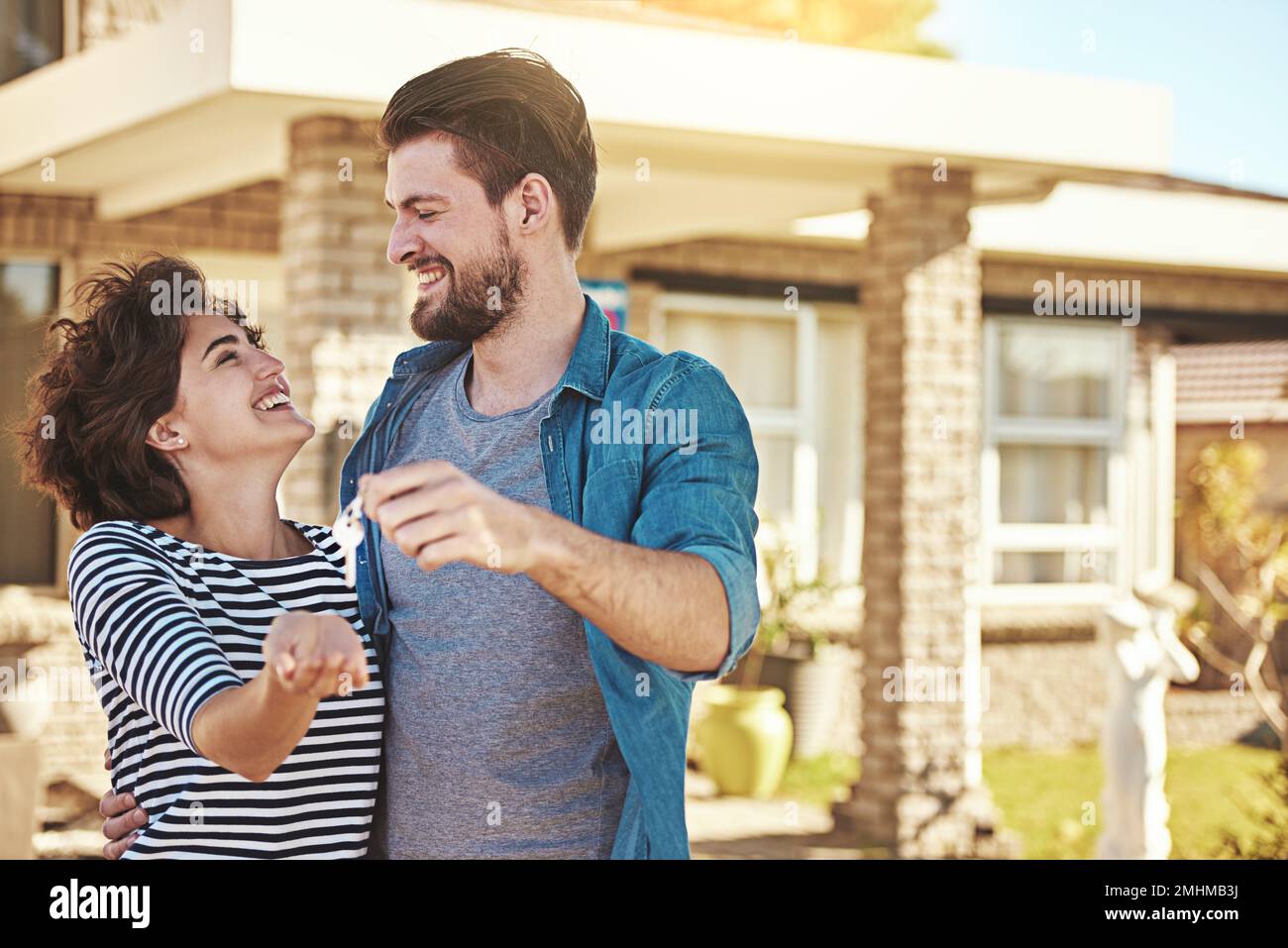 New home, new start. a happy young couple holding the keys to their new ...