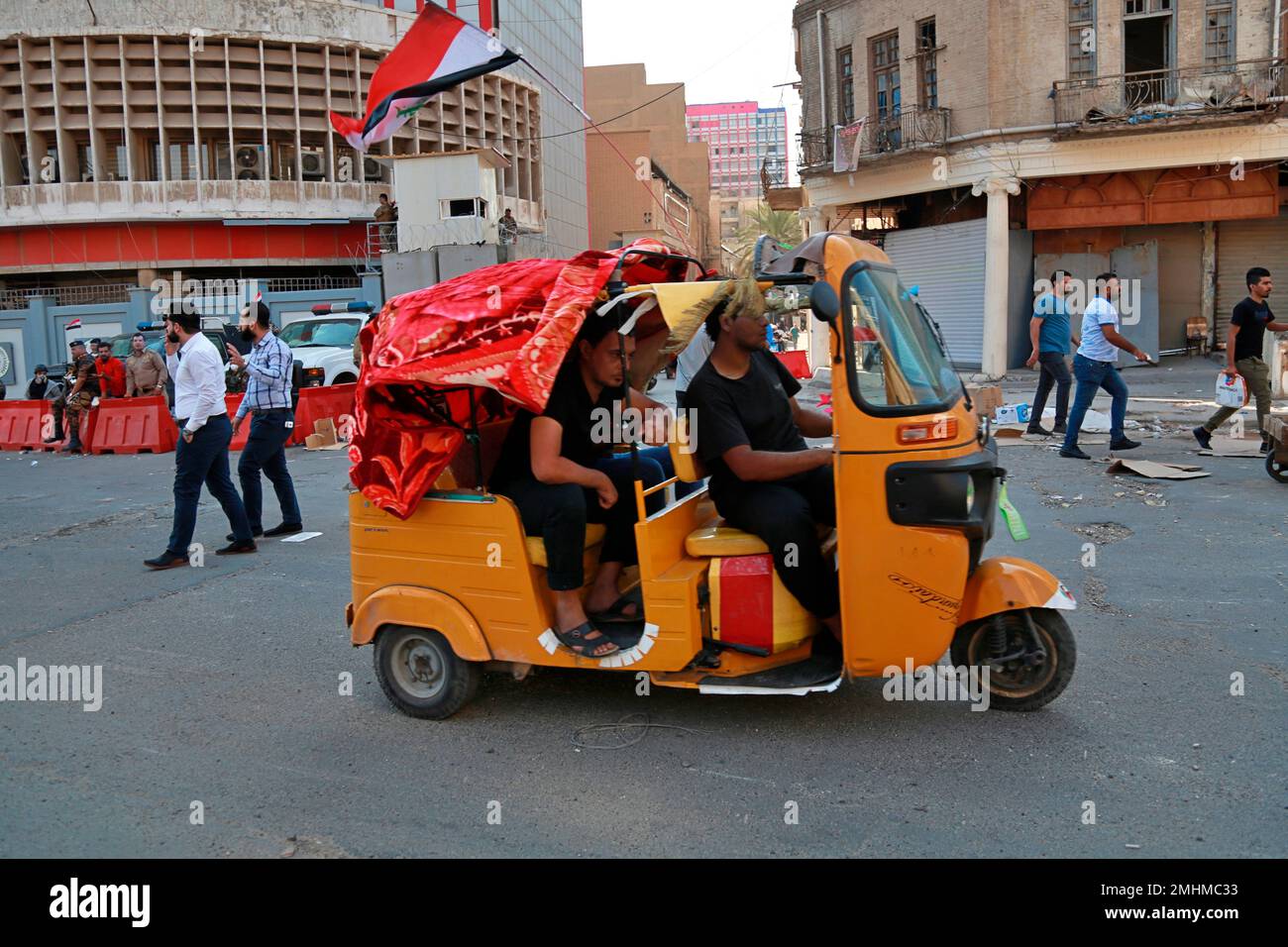 A motorized rickshaw carries protesters as employees leave the central ...