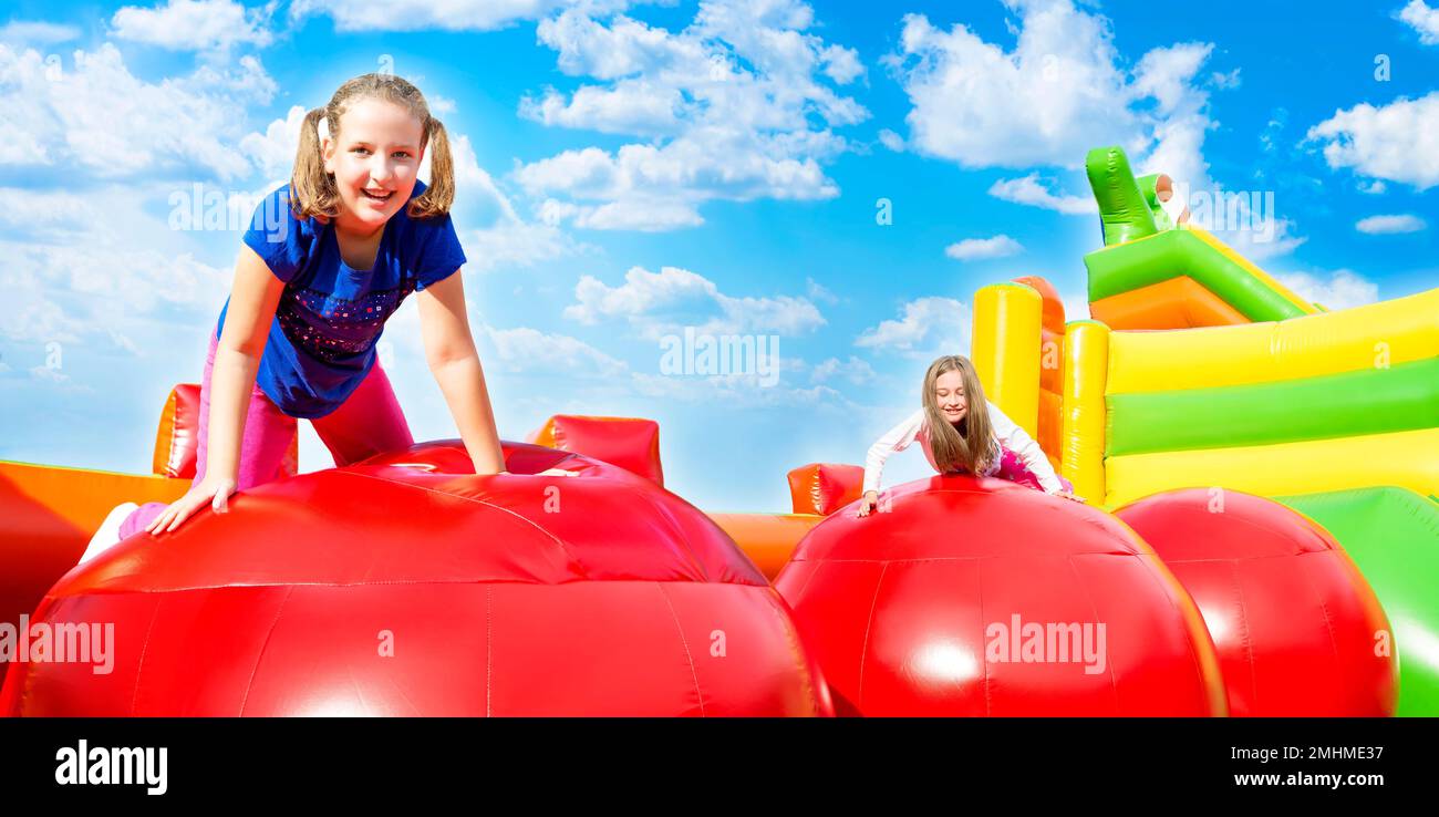 Happy little girls having lots of fun while jumping from ball to ball ...