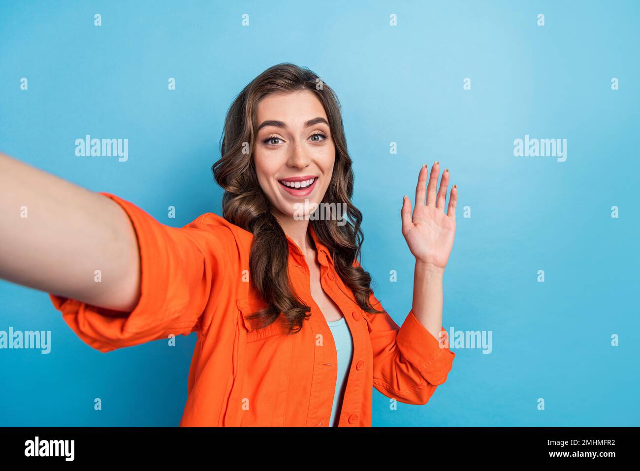 Photo of adorable pretty woman dressed orange jacket waving arm palm ...