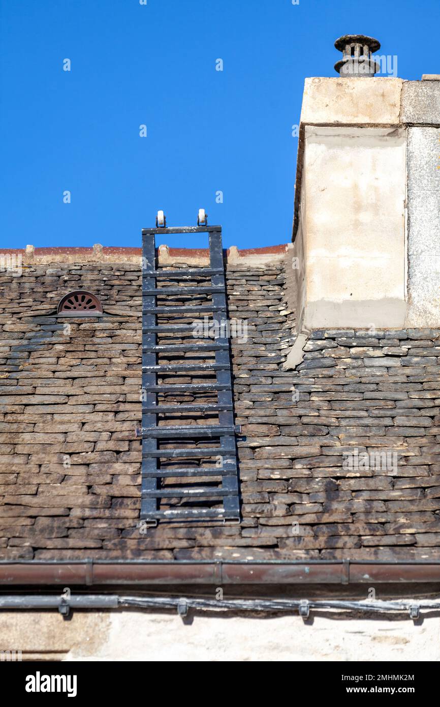 Roof ladder on an old slate roof during the repair of a chimney ...