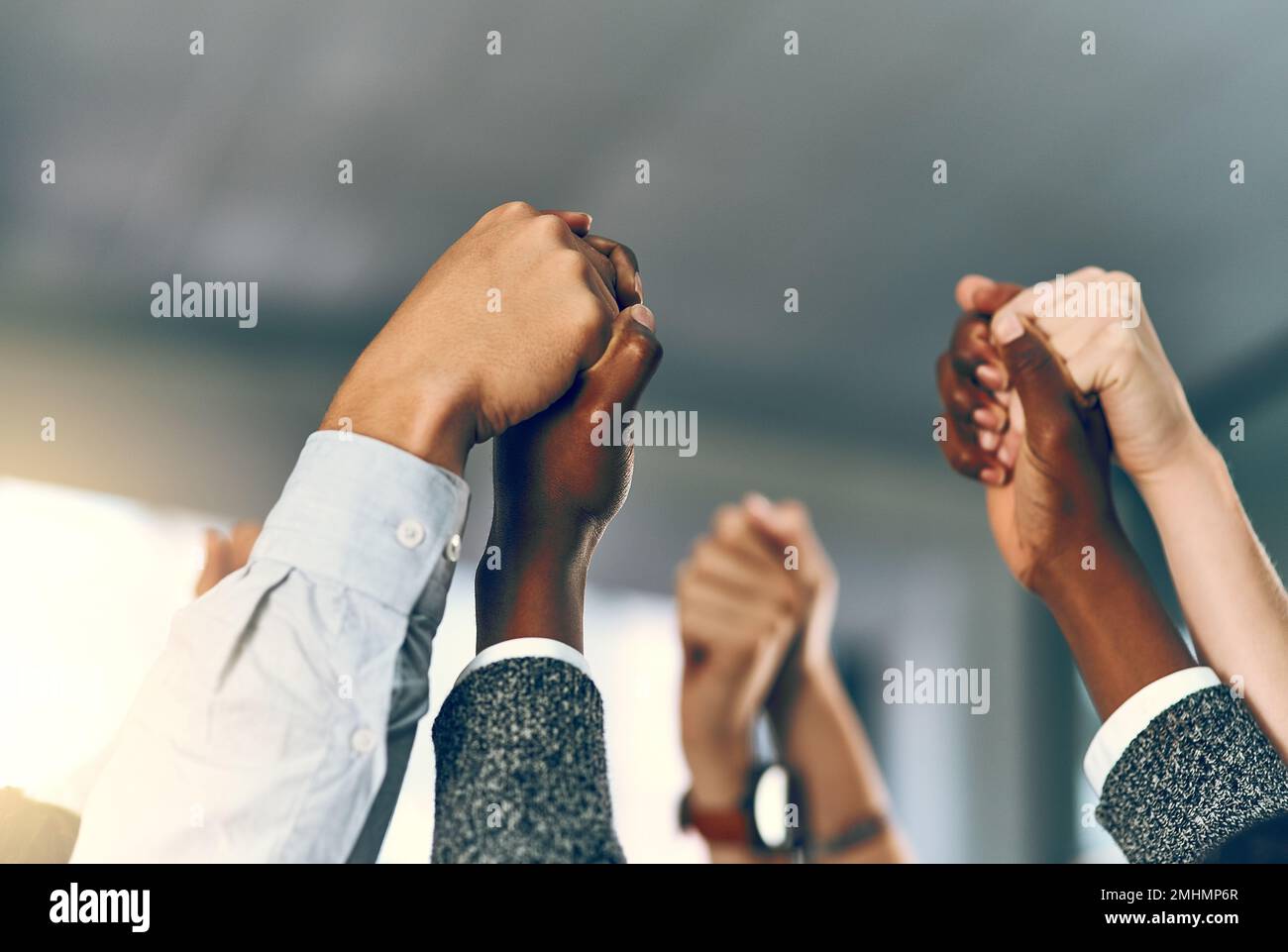 Successful teams support one another. a group of businesspeople holding ...