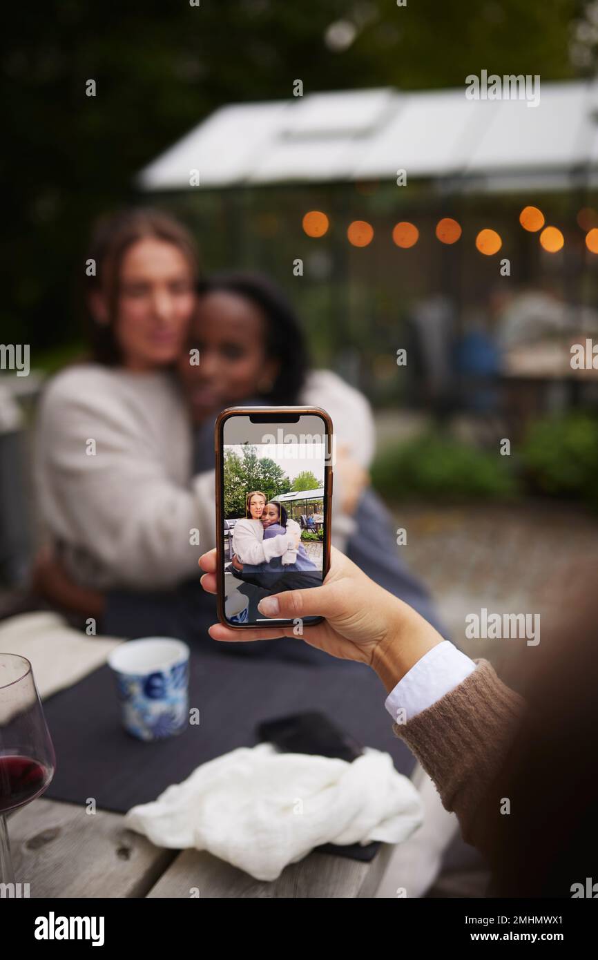 Person taking photo of two female friends Stock Photo - Alamy