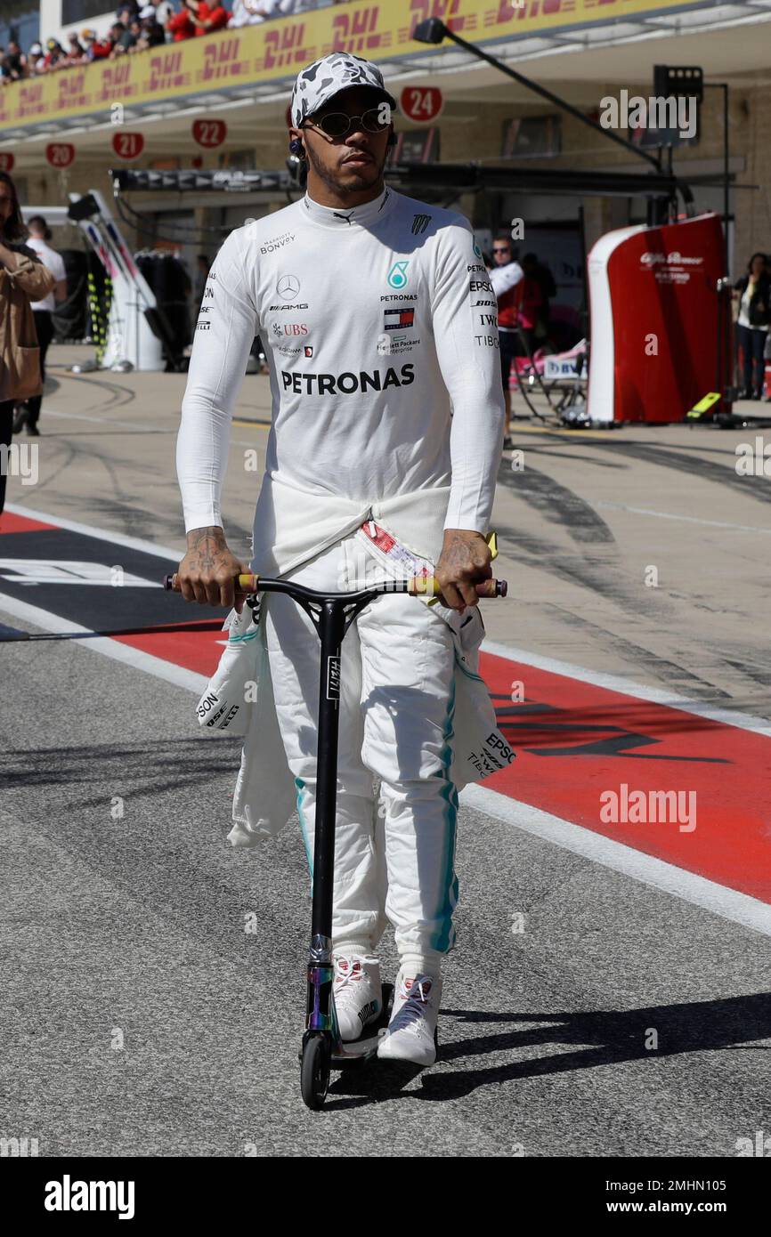 Mercedes driver Lewis Hamilton, of Britain, rides on a scooter before ...