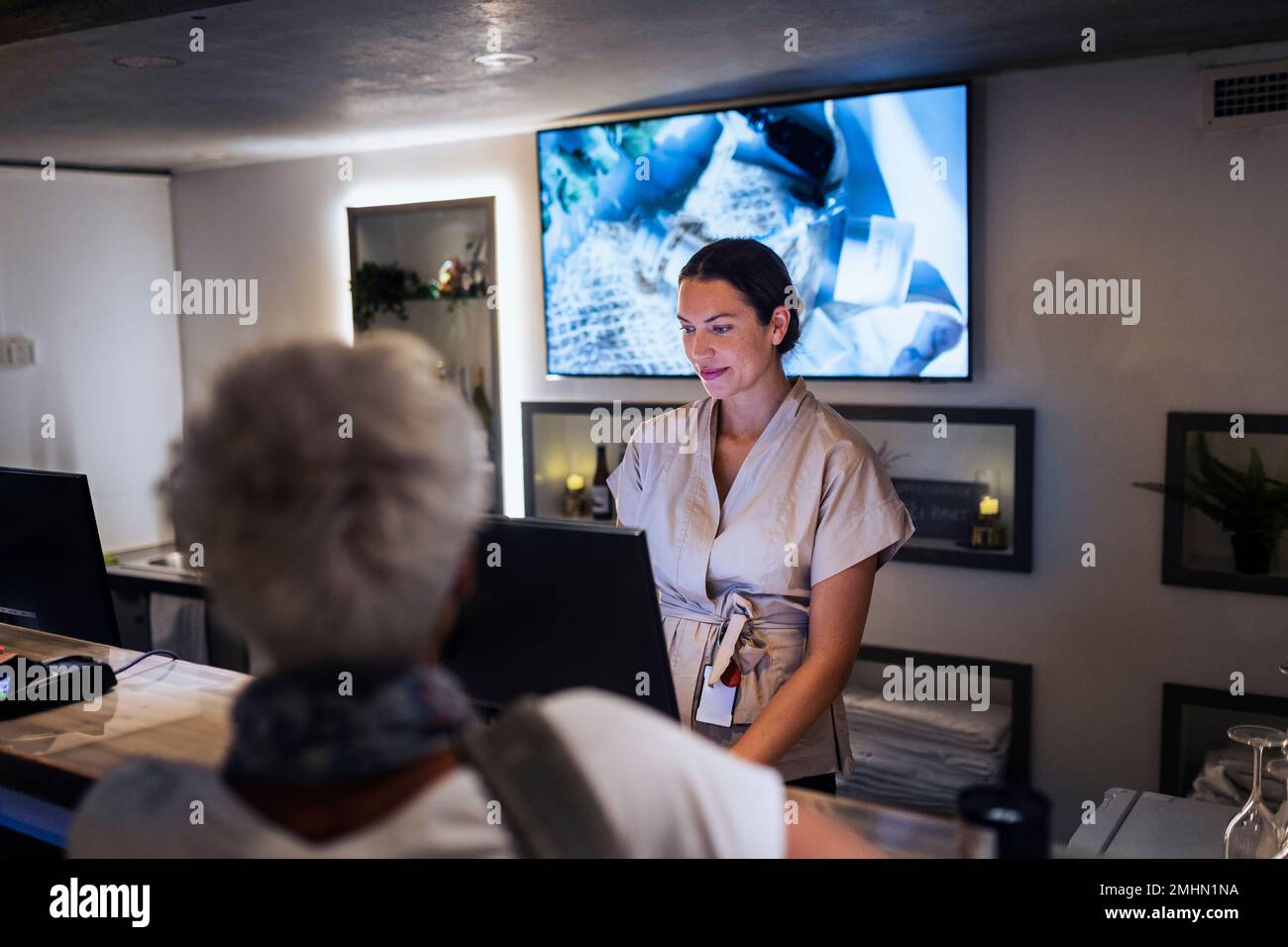 Receptionist assisting customer at health spa Stock Photo - Alamy