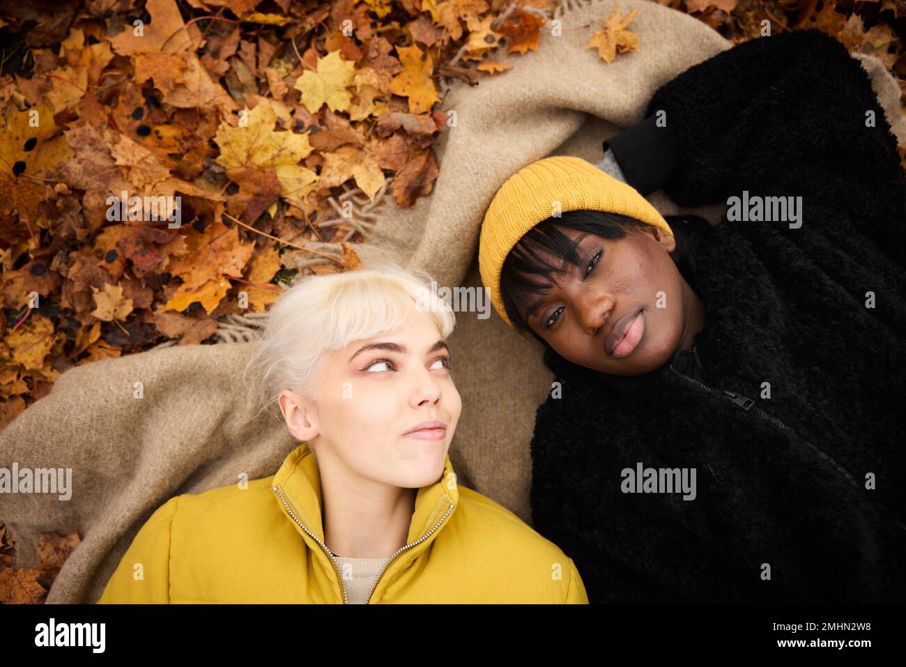 Female friends lying together Stock Photo - Alamy
