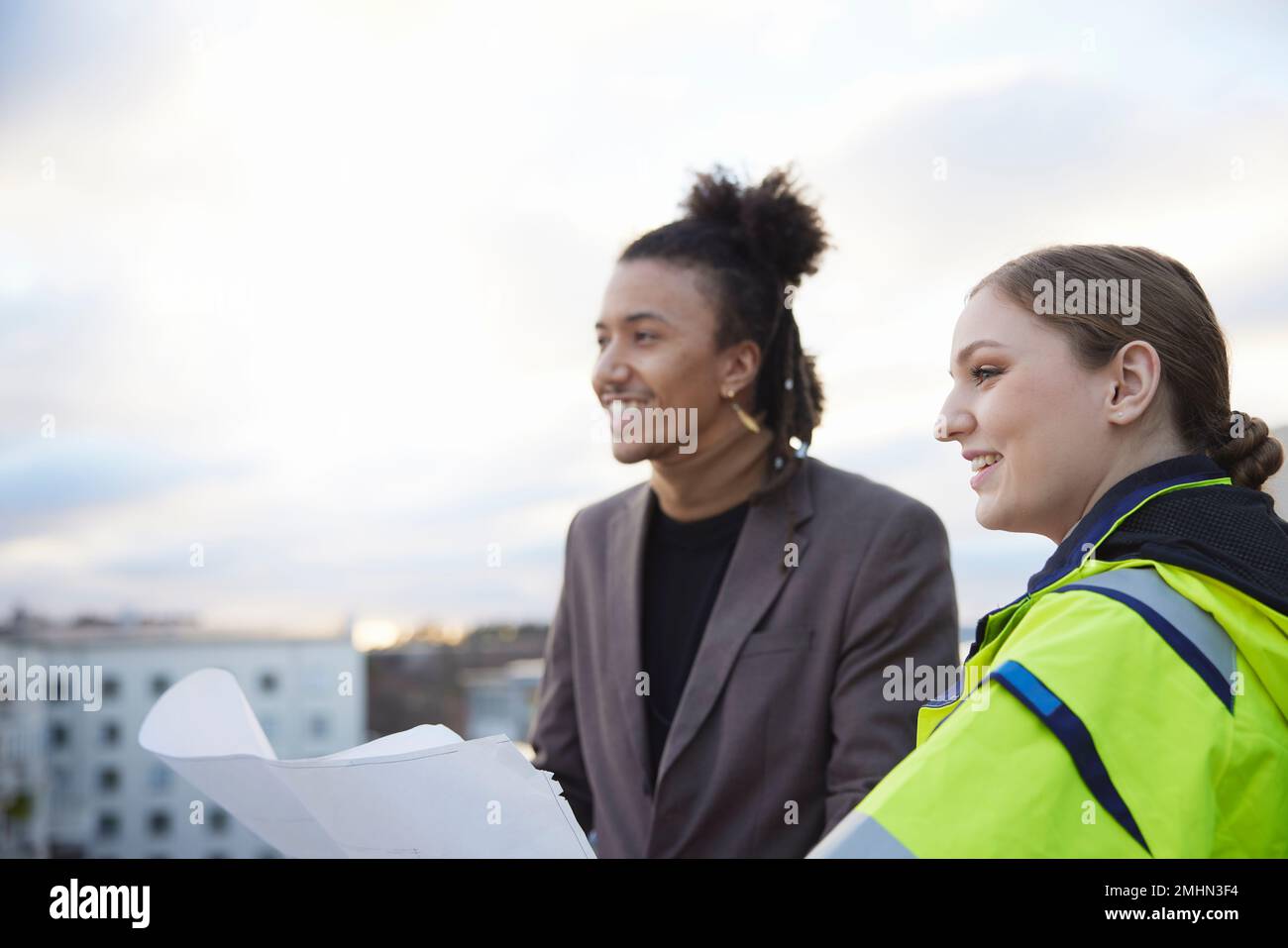 Architects talking while holding blueprints Stock Photo - Alamy