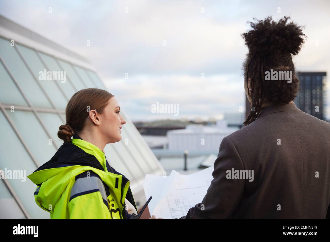 Architects talking while holding blueprints Stock Photo - Alamy