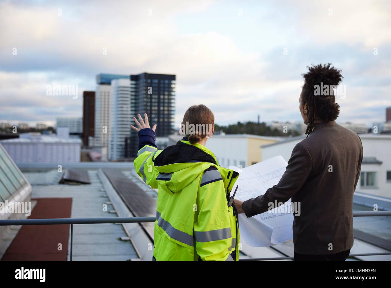 Architects talking while holding blueprints Stock Photo - Alamy