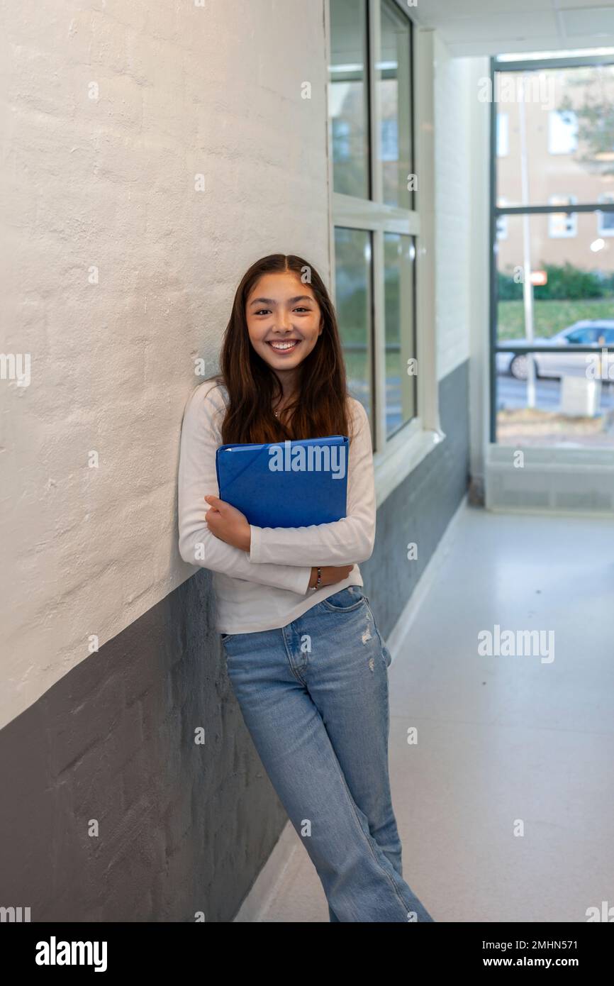 Portrait of teenage girl standing on school corridor Stock Photo - Alamy