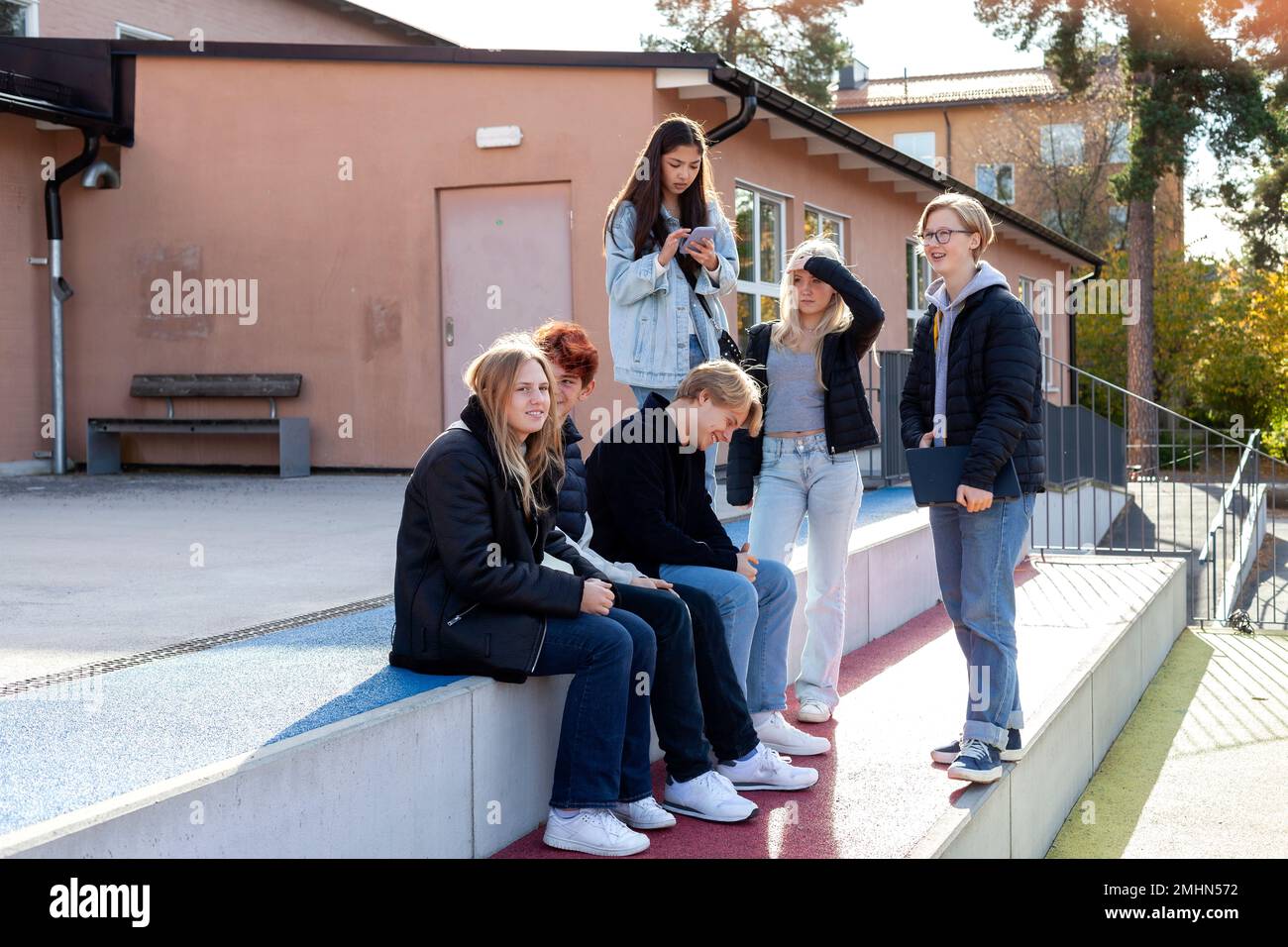 Teenage kids on break in schoolyard Stock Photo - Alamy