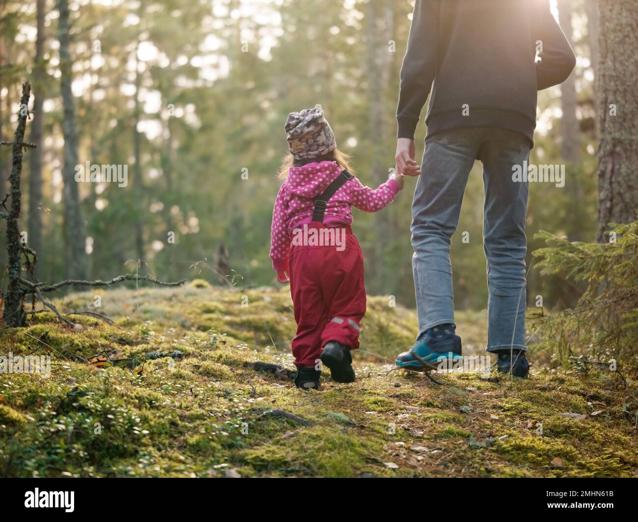 Parent walking with toddler daughter Stock Photo - Alamy