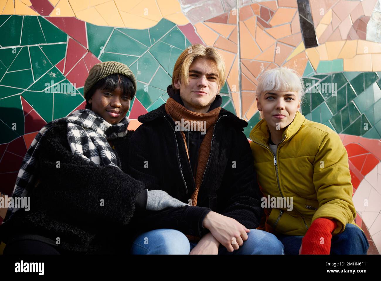 Smiling young friends looking at camera Stock Photo - Alamy