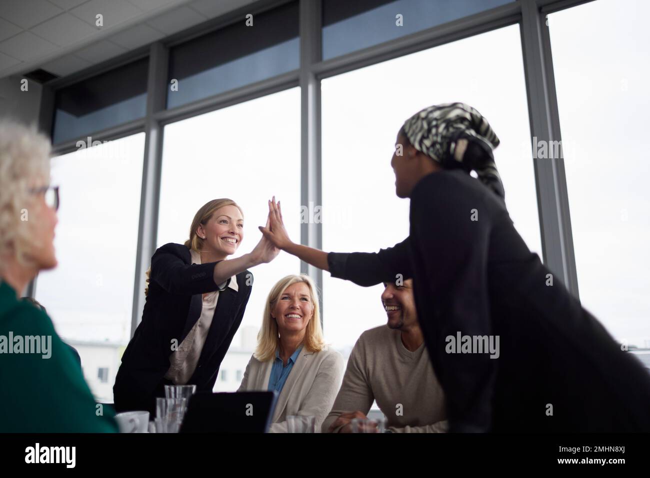 Women giving high five to each other during business meeting Stock ...