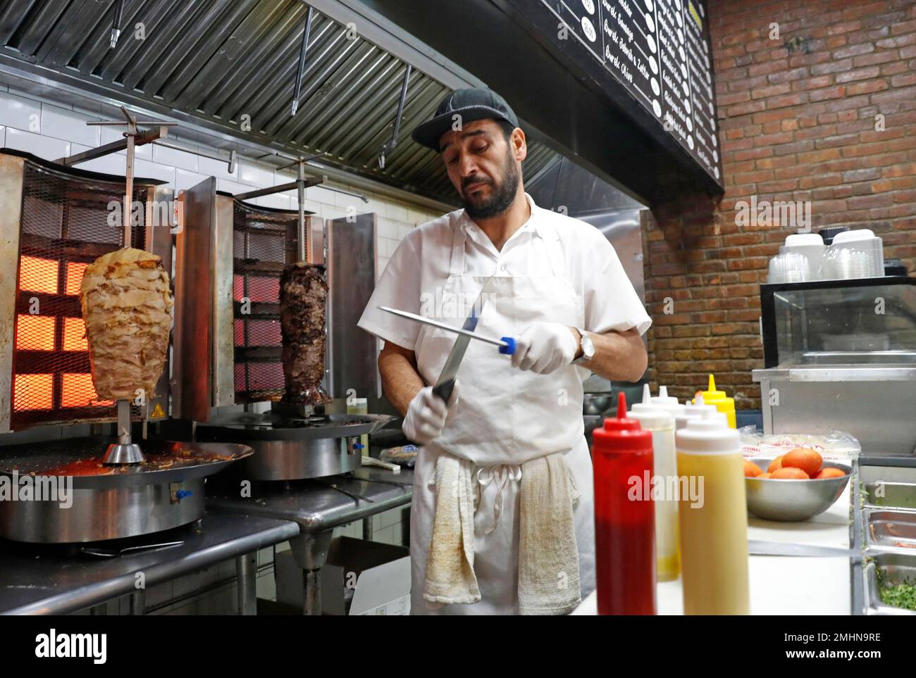 In this Wednesday, Oct. 9, 2019, photo, chef Diaa Alhanoun sharpens his knives between serving ...