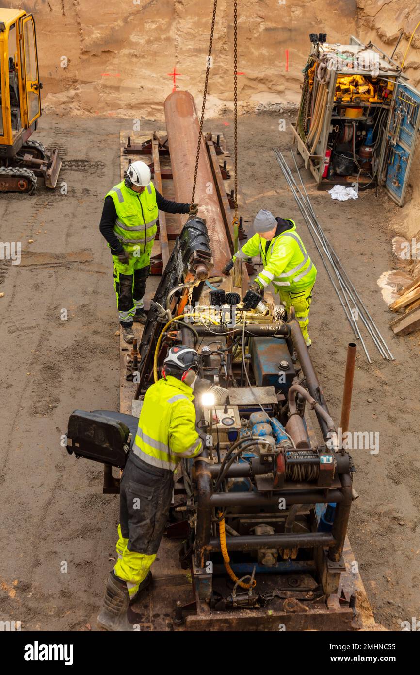 Men installing pipes on construction site Stock Photo - Alamy