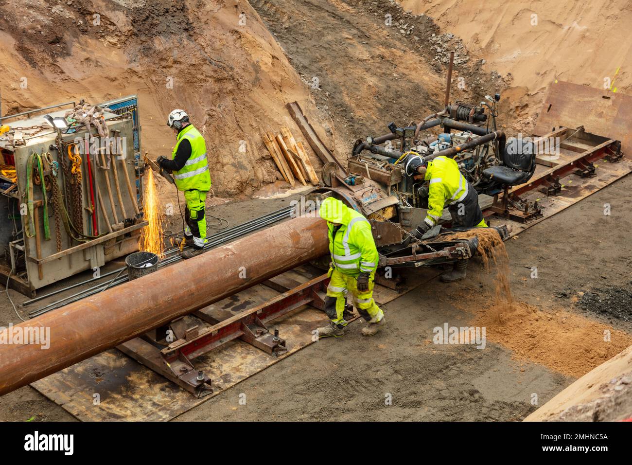 Men installing pipes on construction site Stock Photo - Alamy