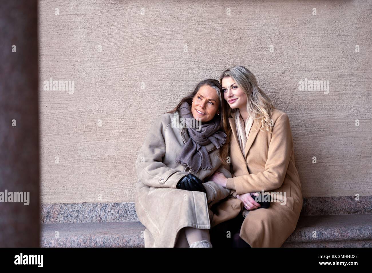 Mother with adult daughter sitting on stone bench Stock Photo - Alamy