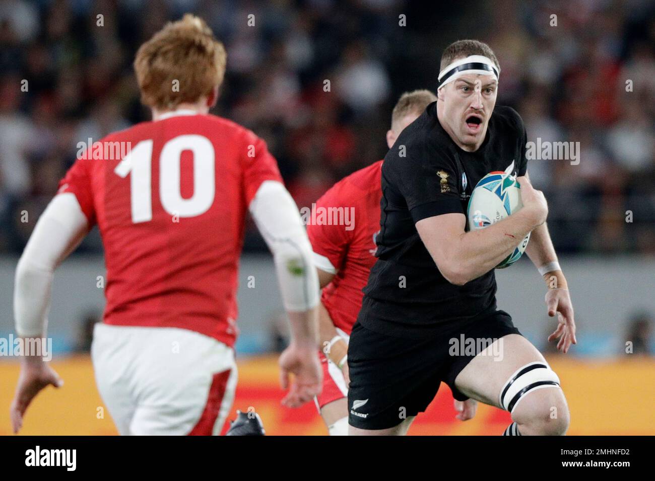 New Zealand's Brodie Retallick, right, runs past Wales' Rhys Patchell ...