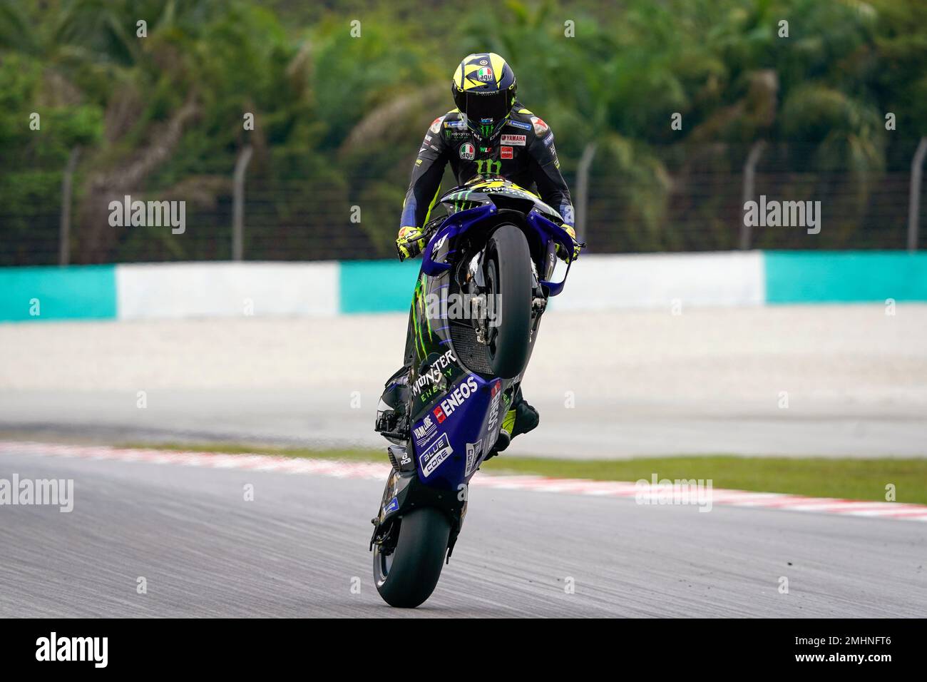Italy's Valentino Rossi does a wheelie on his Yamaha during the second ...