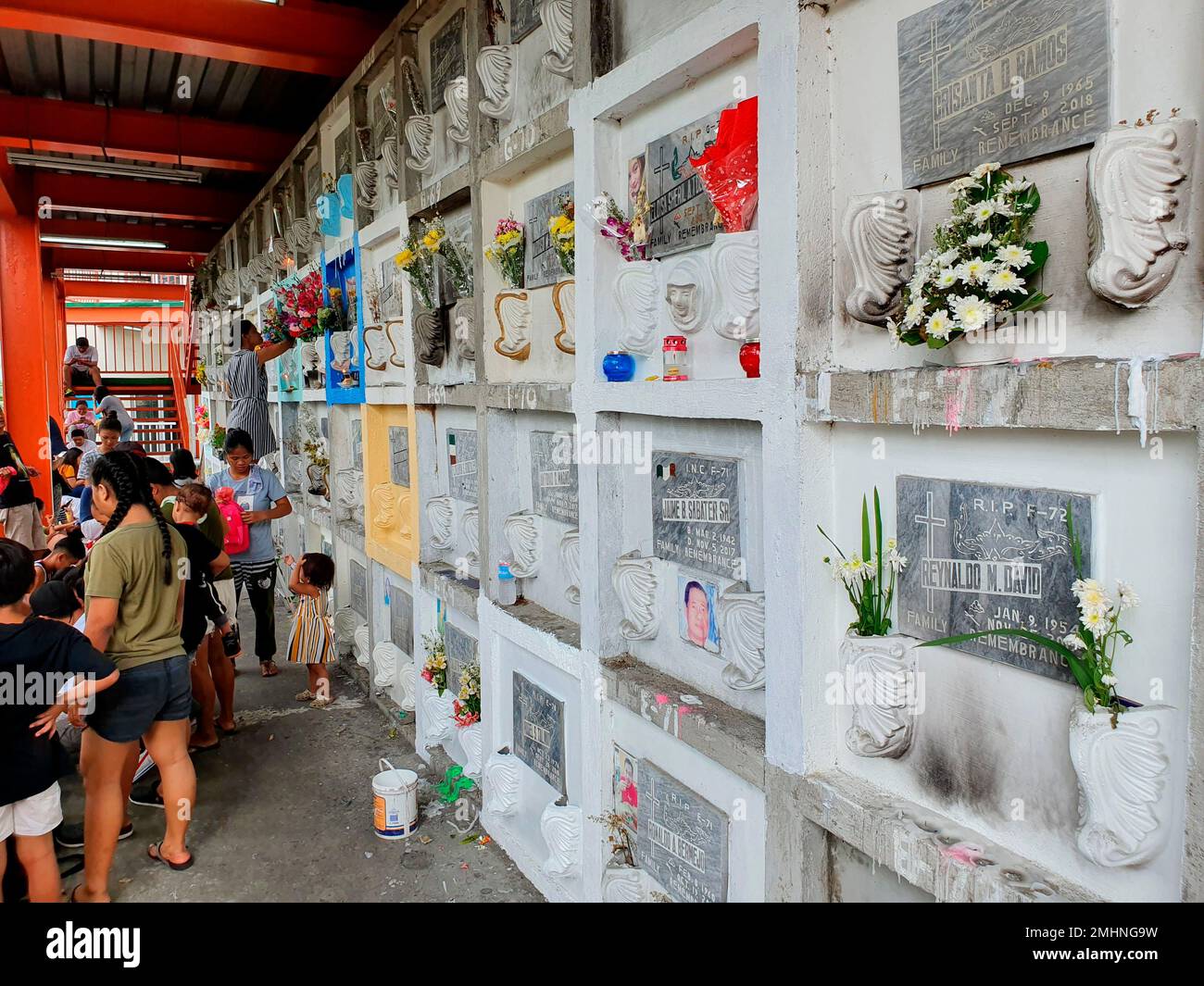 Rows of freshly painted tombstones are adorned with flowers brought by ...