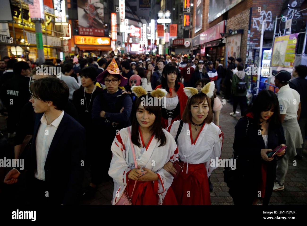 A large crowd of people dress up and walk around on the streets for ...
