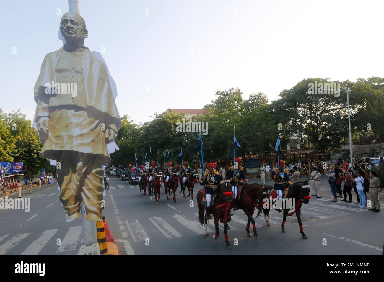 Indian policemen ride past a cut-out of Sardar Patel as they ...