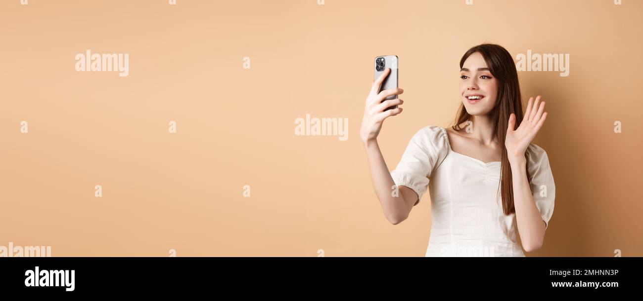 Girl video chat on phone, waiving hand at mobile camera and saying ...