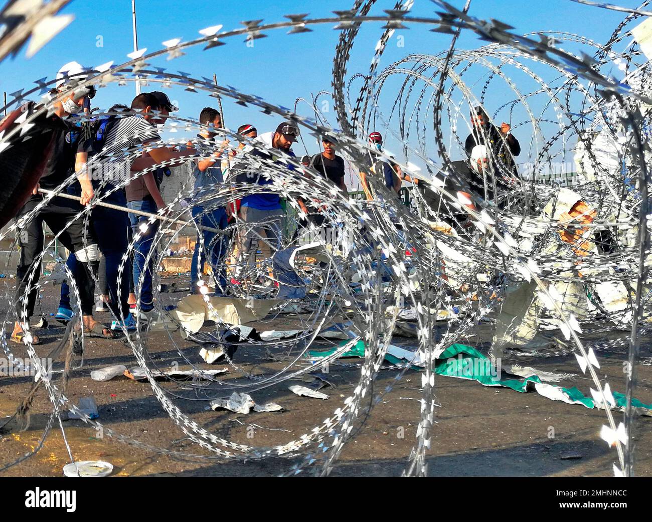 Iraqi anti-government protesters remove barriers set by security forces ...