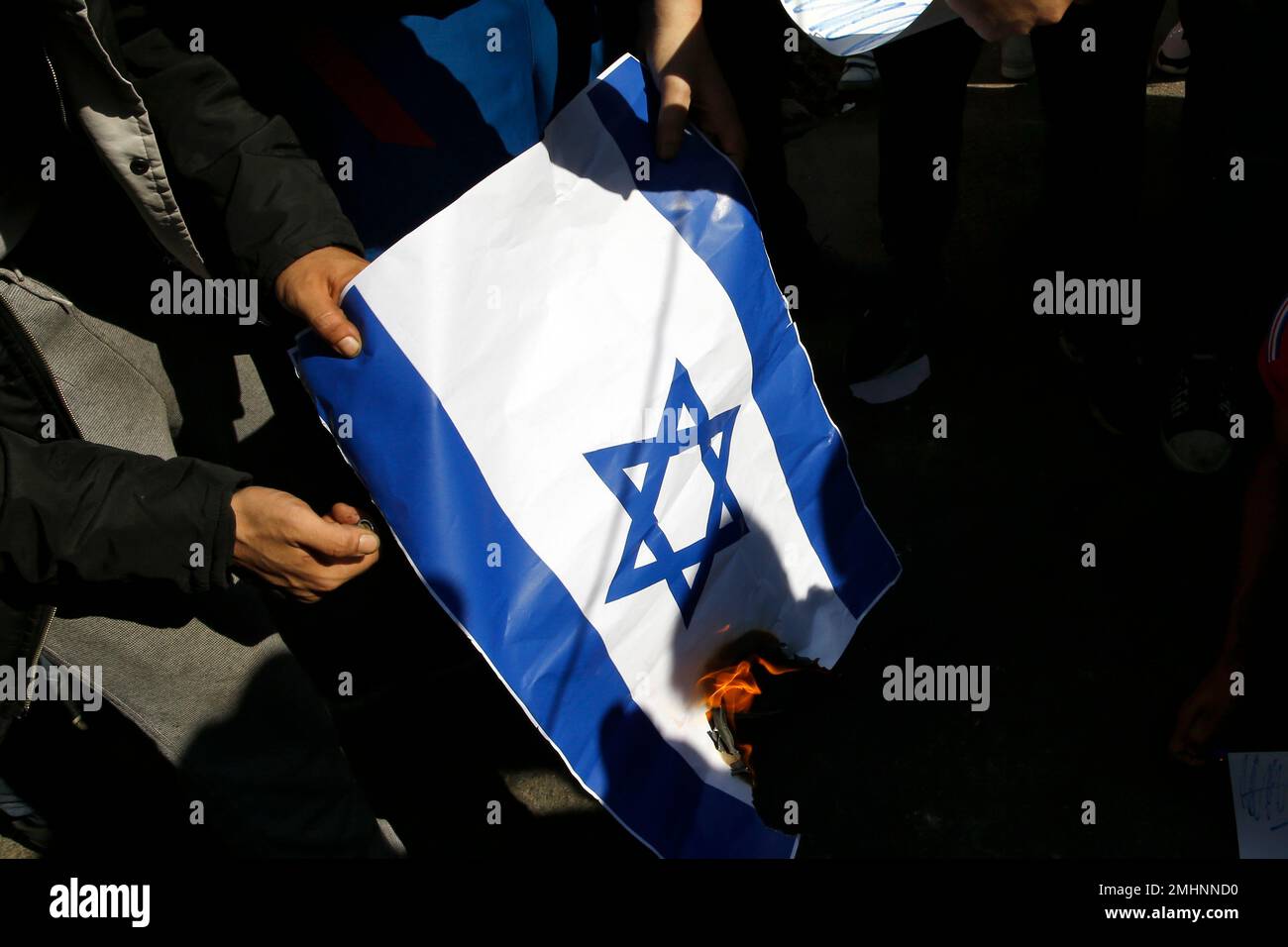 Anti-government protesters burn an Israeli flag after riot police open ...