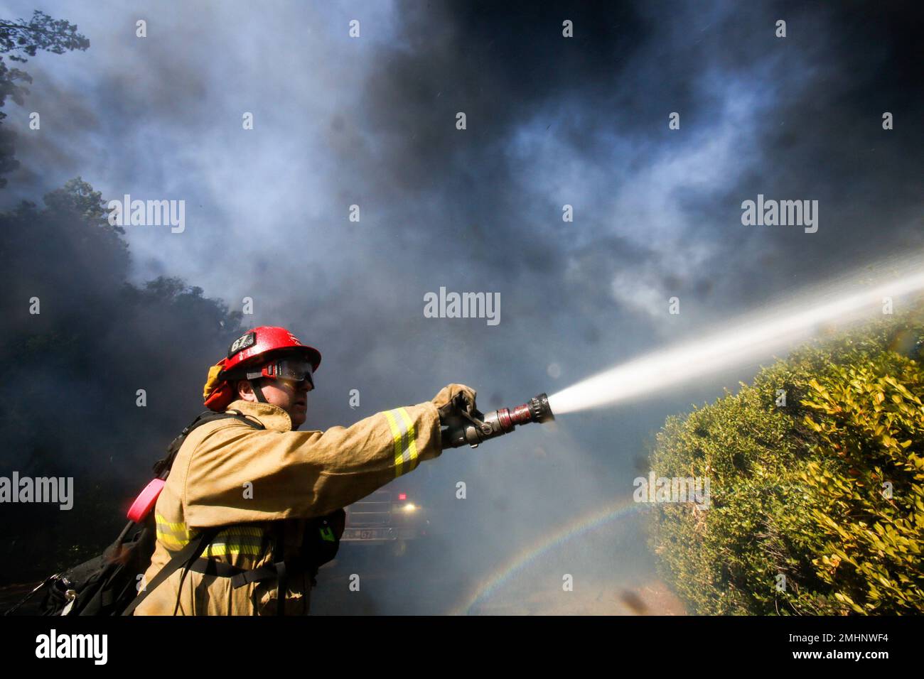 A firefighter battles a wildfire near a ranch in Simi Valley, Calif ...