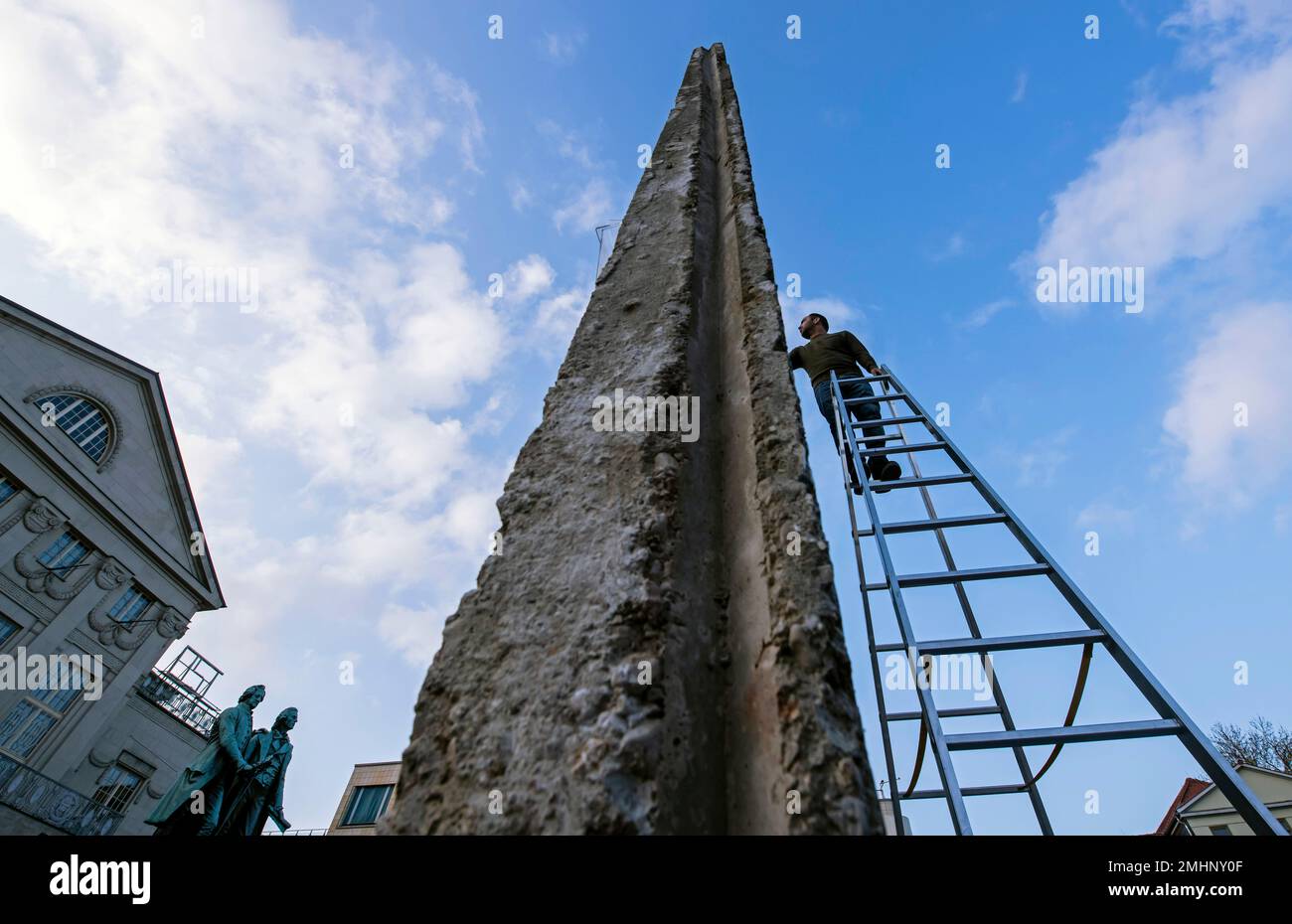 An artist looks over the wall during the art performance 'Wall watching ...
