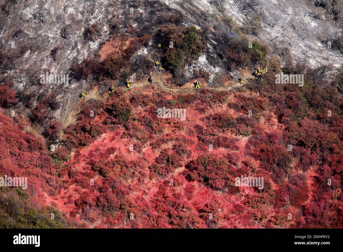 Hand crews work on a hillside as the Getty fire burns on Kenter Canyon ...