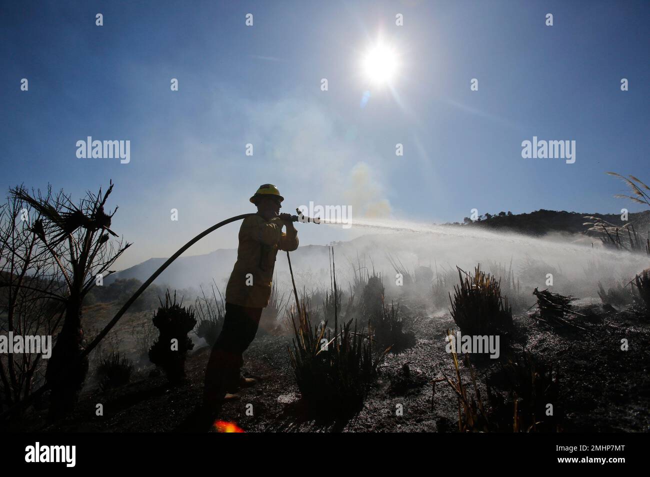 A firefighter puts out hotspots near the Getty Fire area in Los Angeles ...