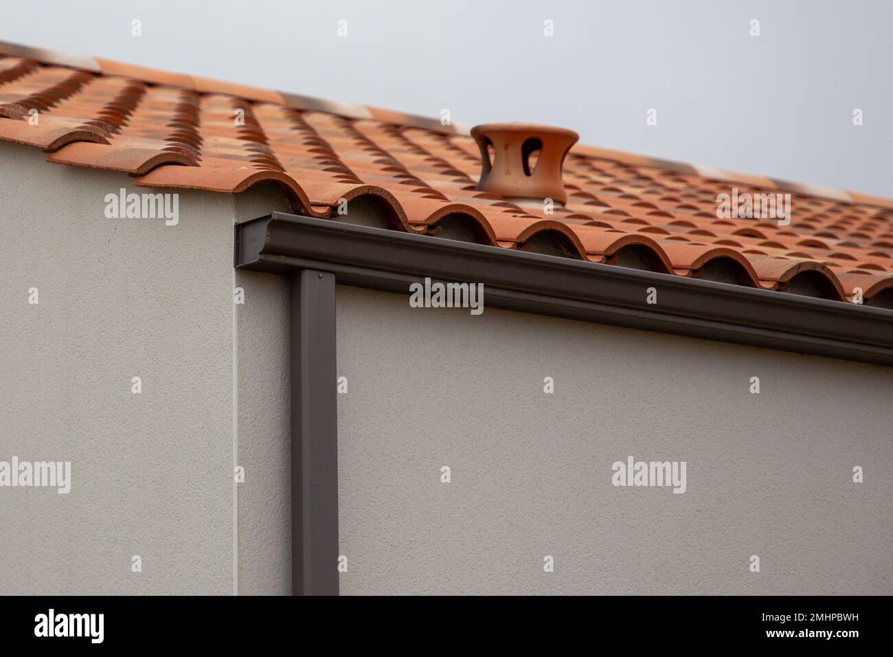 grey rain gutters gray facade roof tiles on a home Stock Photo - Alamy