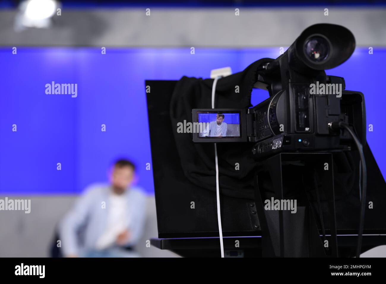 Presenter working in studio, focus on video camera Stock Photo - Alamy