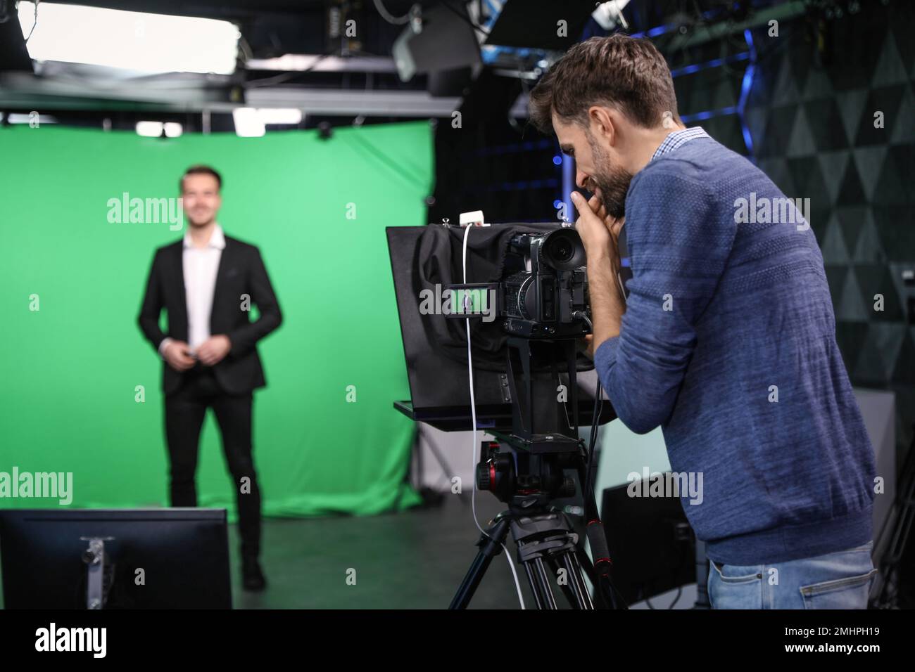 Presenter and video camera operator working in studio. News ...