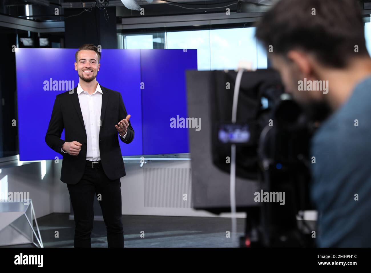 Presenter and video camera operator working in studio. News ...
