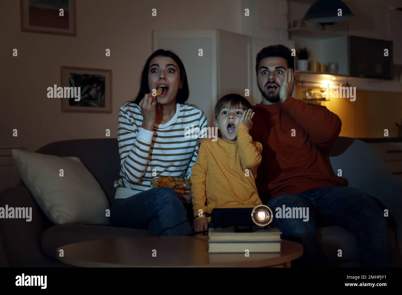 Emotional family watching movie using video projector at home Stock ...