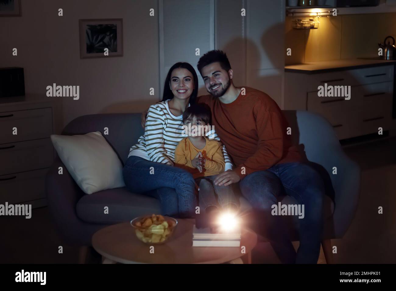 Family watching movie using video projector at home Stock Photo - Alamy