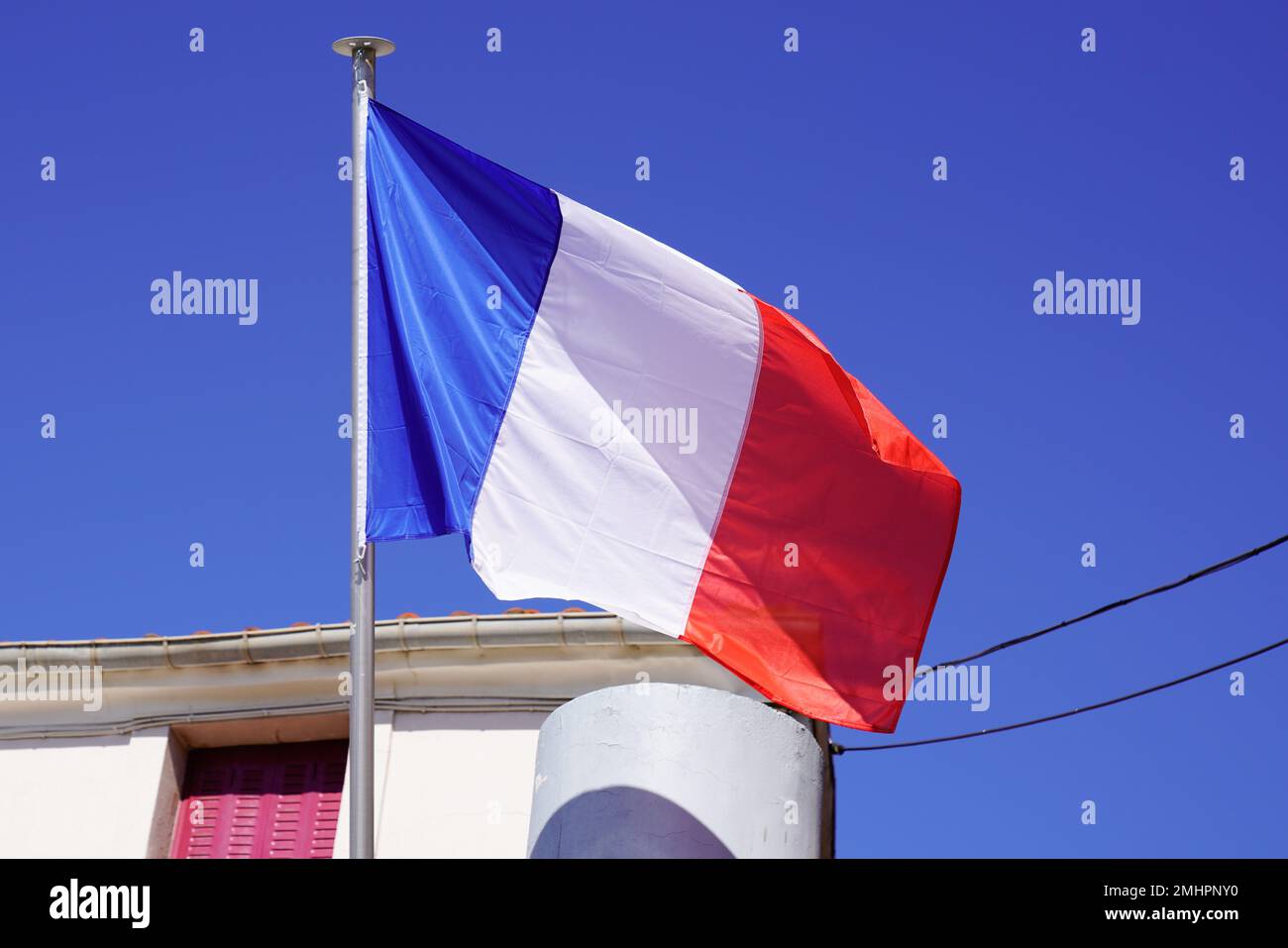 French blue white red flag waving in mat front of city hall in town of ...