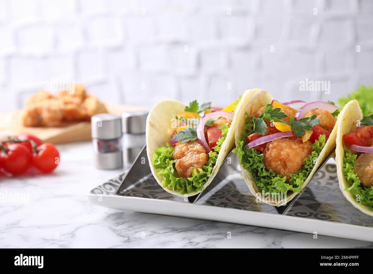 Yummy fish tacos served on white marble table Stock Photo - Alamy