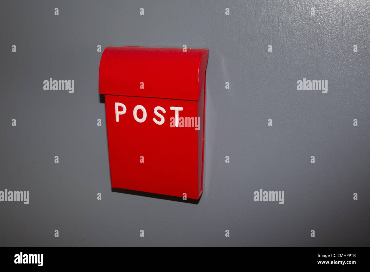 british red post box on grey wall background Stock Photo - Alamy