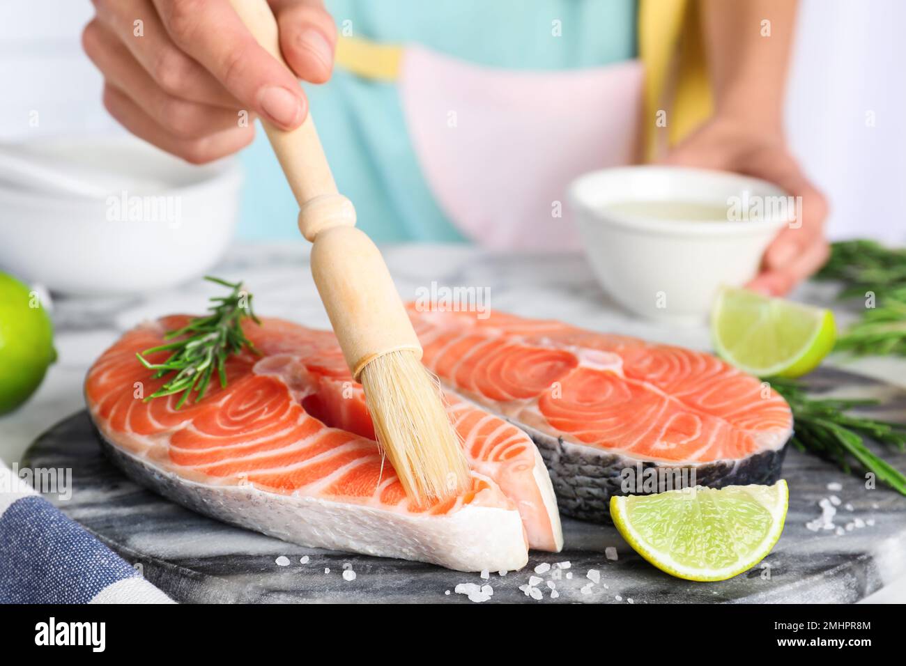 Woman marinating fresh raw salmon at table, closeup. Fish delicacy ...