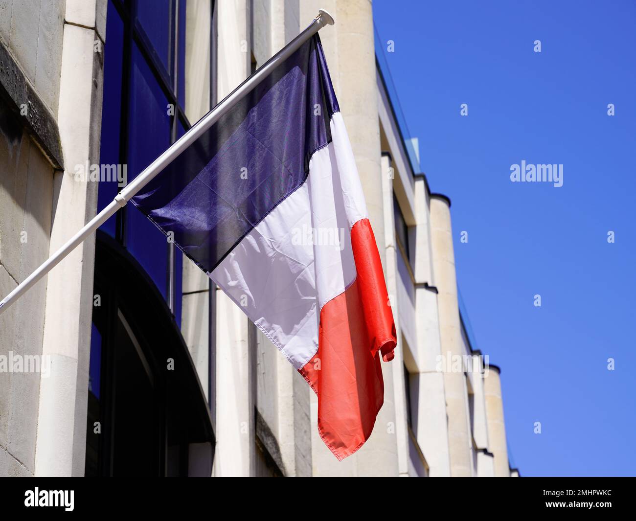 French flag waving in front facade of city hall in town of france Stock ...