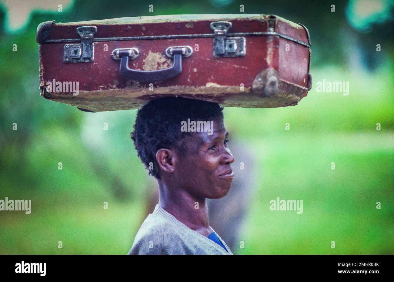 Zambia. Woman carrying suitcase on her head Stock Photo - Alamy