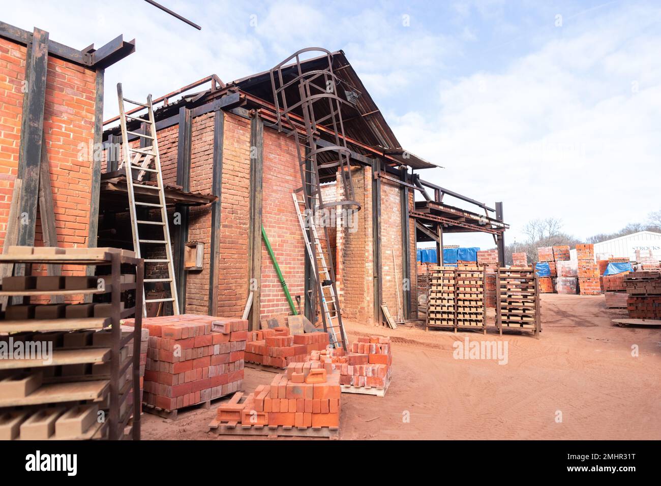 A building under construction with red bricks on the ground Stock Photo ...